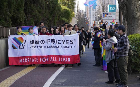 Plaintiffs Holding A Banner Walk Towards The Tokyo District Court For